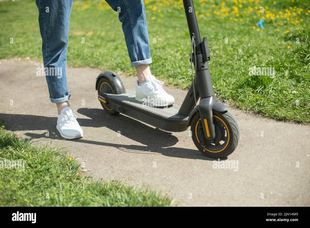 Guy on electric scooter. Man put his foot on platform of scooter ...