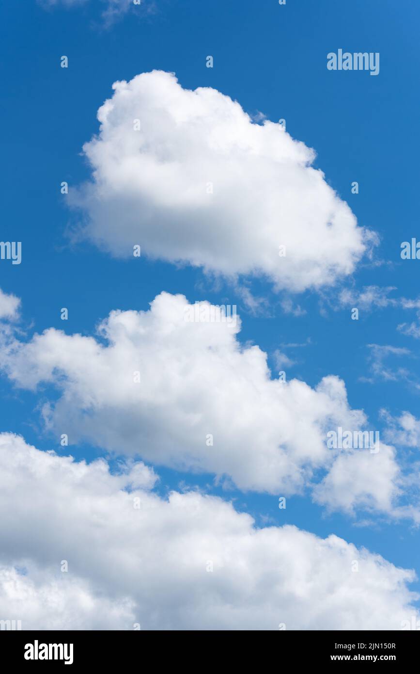 Fluffy white clouds in clear blue sky Stock Photo - Alamy