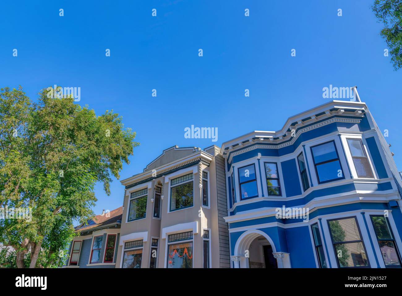 Adjacent middle class homes with decorative trims and bay windows at ...