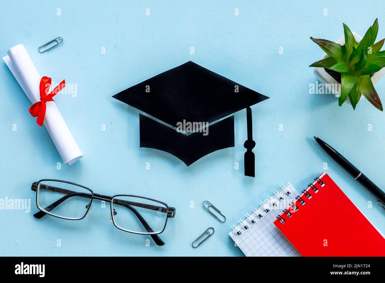 Black academic cap or graduation hat on students table, top view Stock ...