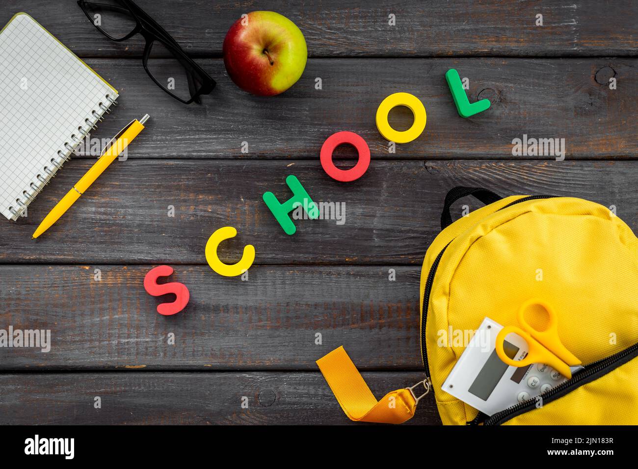 Layout of yellow school backpack full of stationery with apple Stock ...