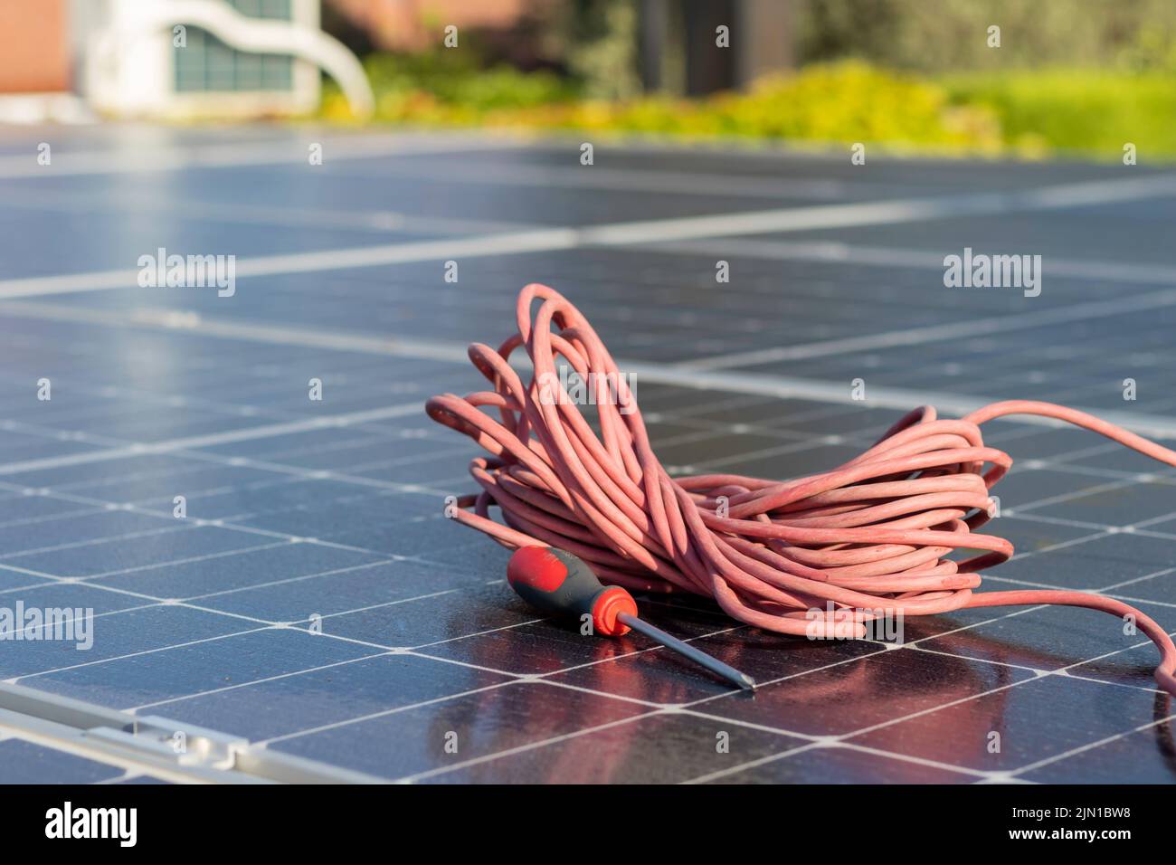 Red cable reel and a screwer prepared to get the photovoltaic solar ...