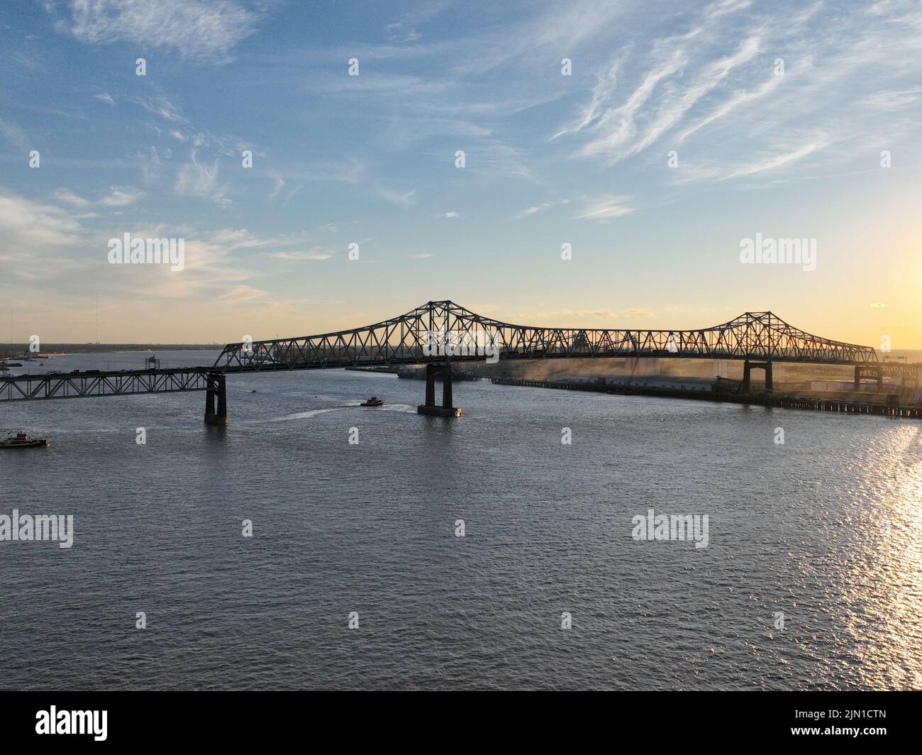 An aerial view of a metal bridge above the Mississippi river at sunset ...