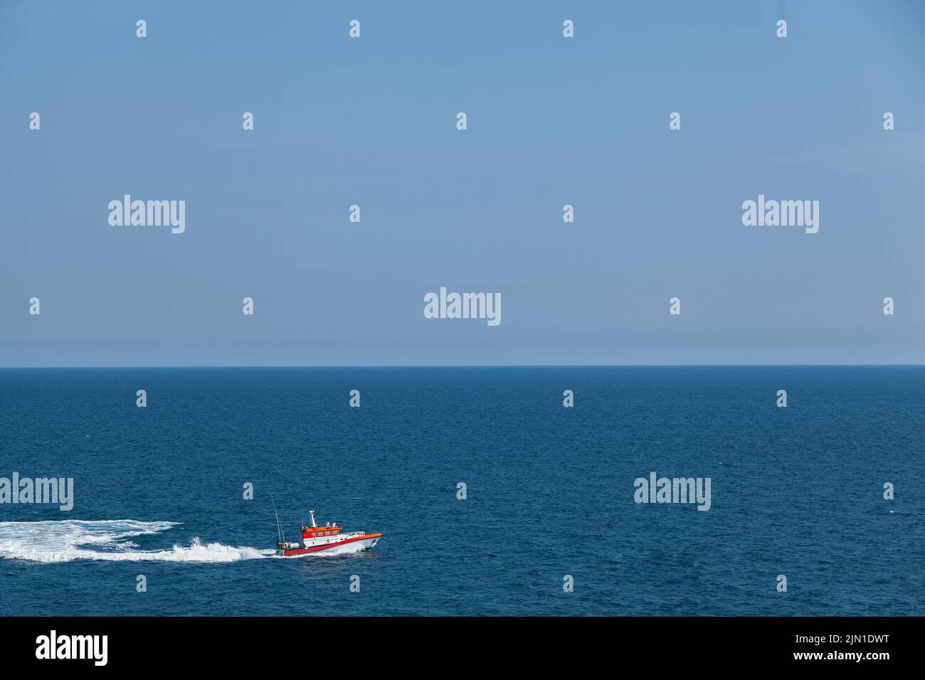 Search and rescue boat floats on the waves at speed. The horizon is ...