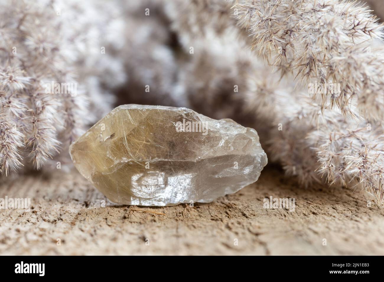 quartz with rutile crystal mineral stone over natural wooden background ...