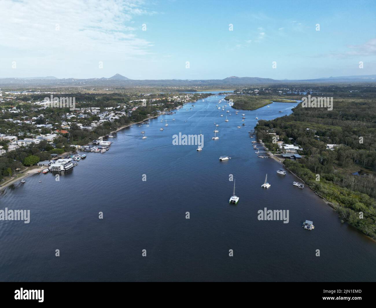 An aerial view of a river with a small port and sailing boats in a ...