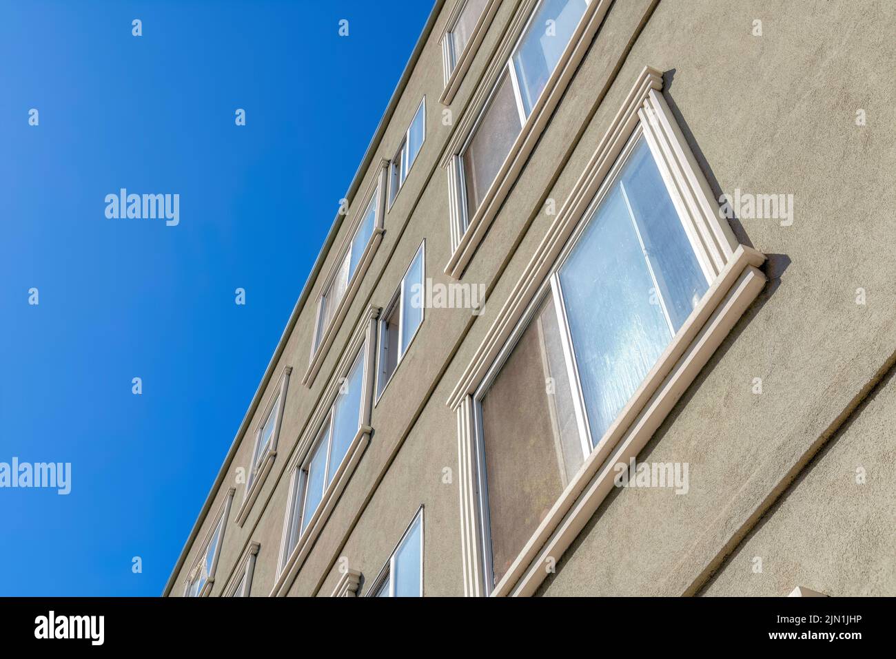 Gray stucco wall and sliding window with screen of an apartment ...