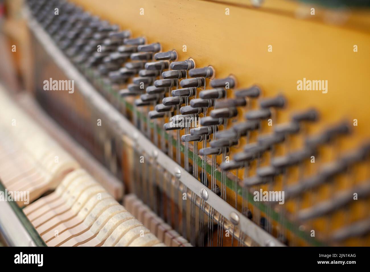 The inside of the piano is without a lid. Strings, hammers and other ...