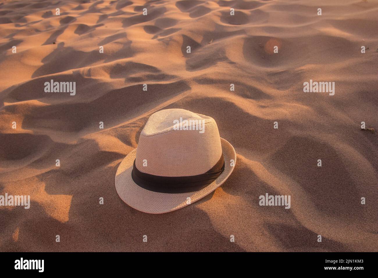 Selective focus of straw hat isolated on a sandy background, straw hat ...