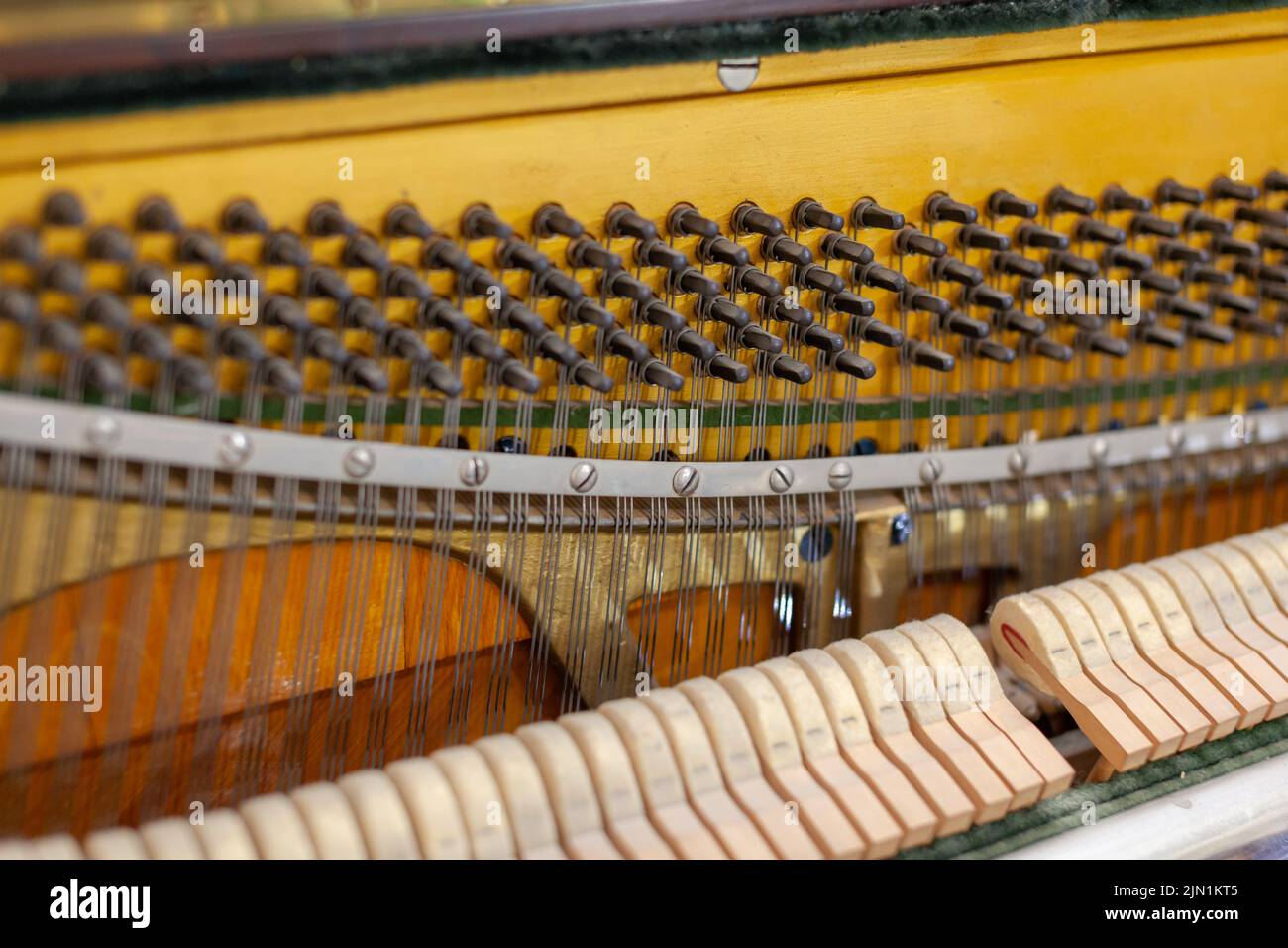 The inside of the piano is without a lid. Strings, hammers and other ...