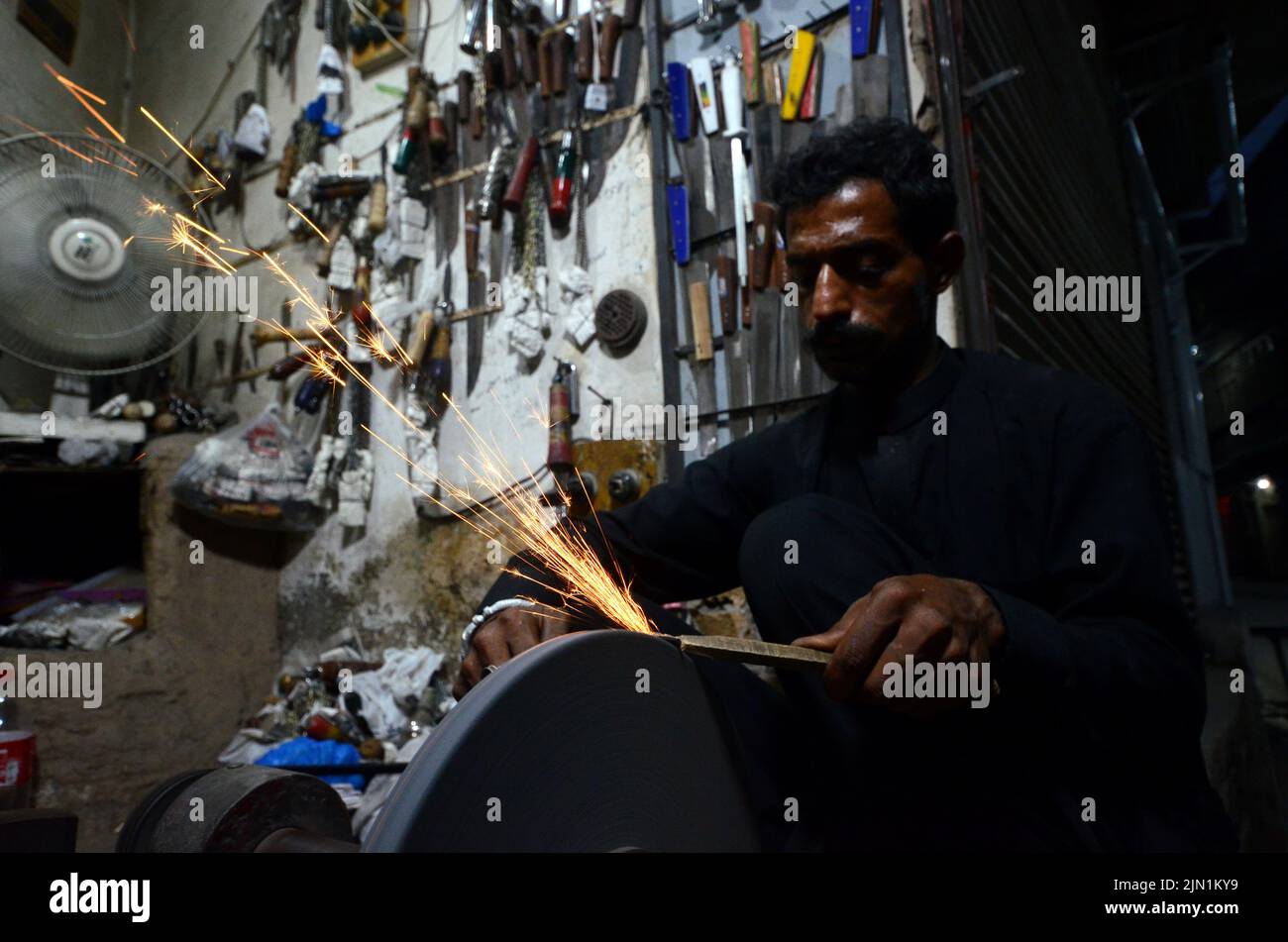 Peshawar, Pakistan. 07th Aug, 2022. An ironsmith sharpens knives to be ...