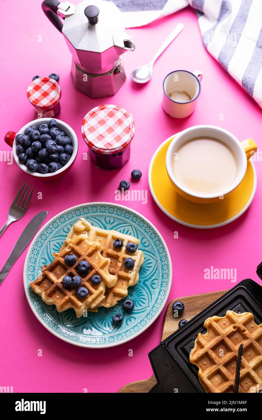 morning and bright breakfast on the pink background. belgian waffles ...