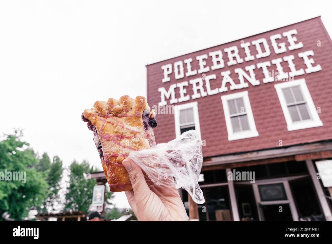Polebridge, Montana - July 3, 2022: Hand holds up a famous huckleberry ...