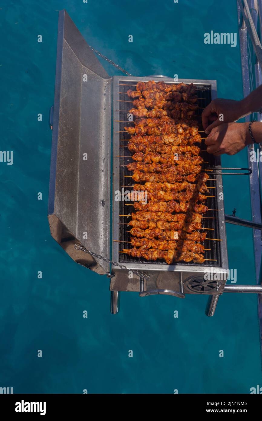 Barbecue on the boat on the sea, on the turquoise sea background, top ...