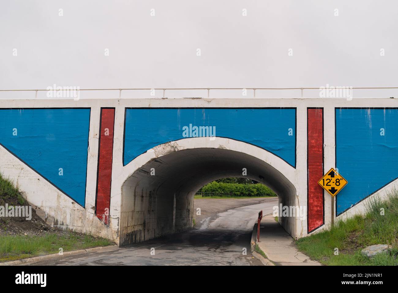 Colorful red, white and blue painted railroad bridge is considered the ...