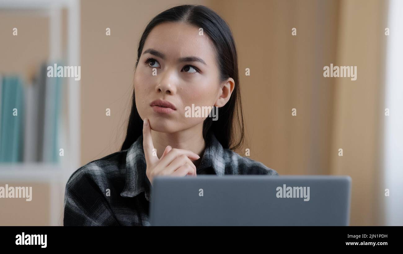 Thinking student girl asian pensive woman portrait works laptop doing ...