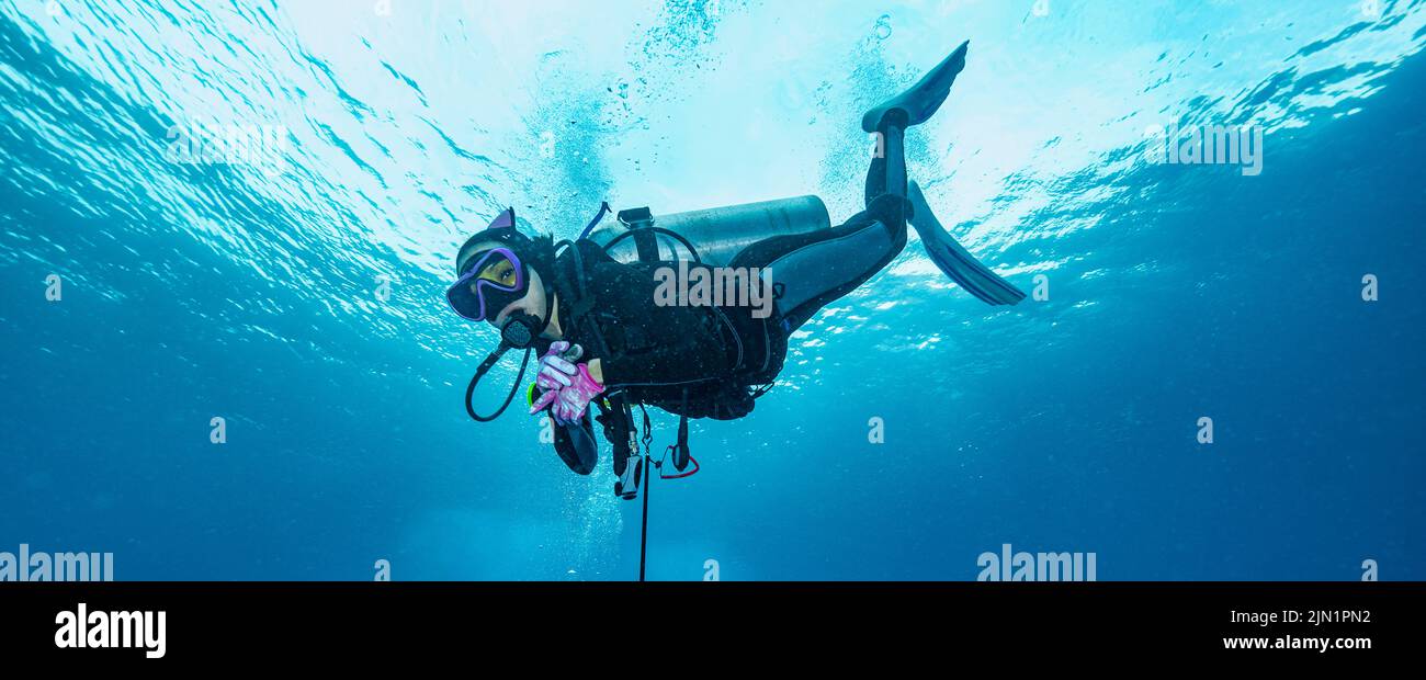Diver emerging into the tropical waters of the Andaman Sea Stock Photo ...