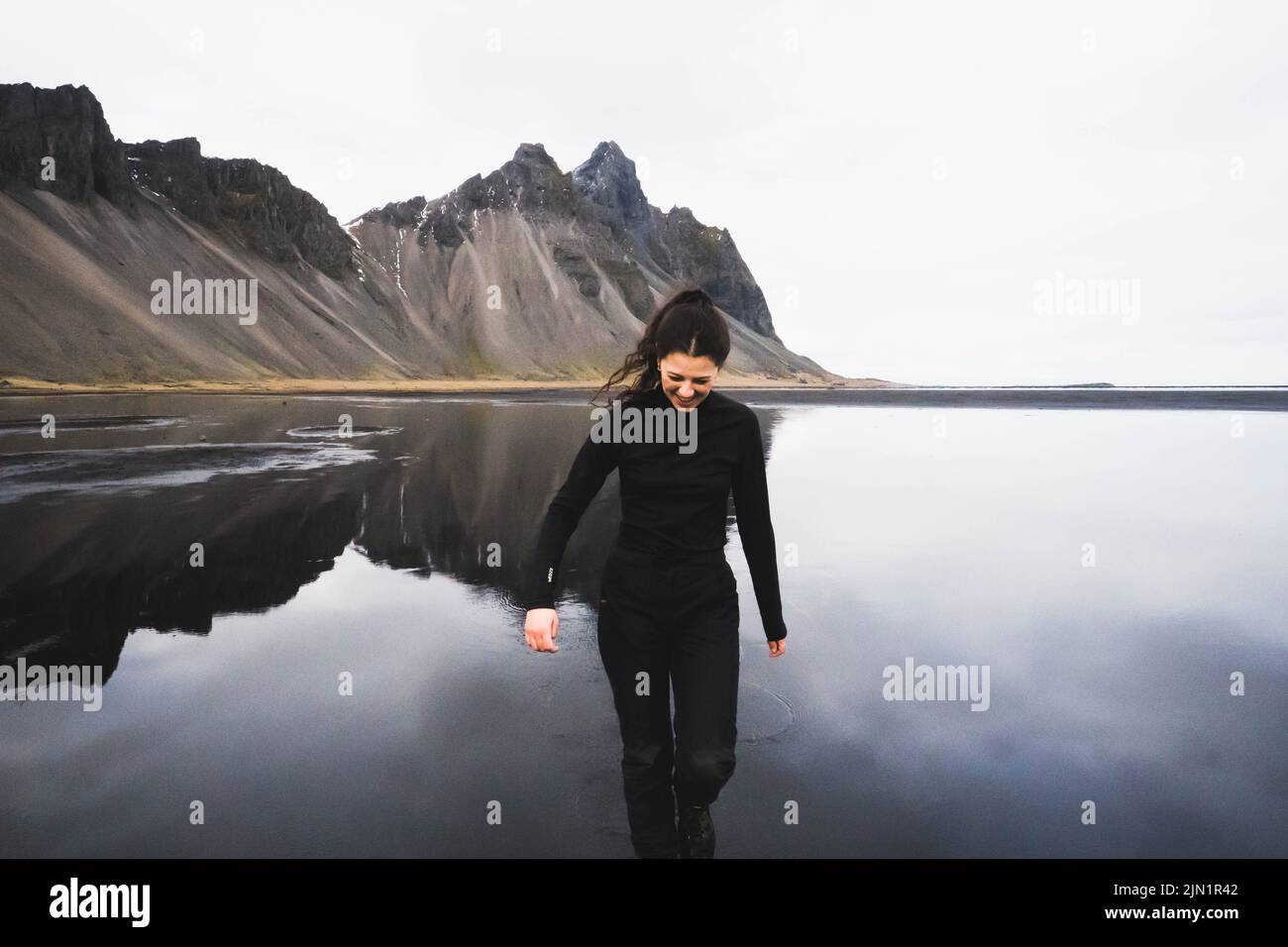 woman and her reflection on reflecting beach against mountains Stock ...