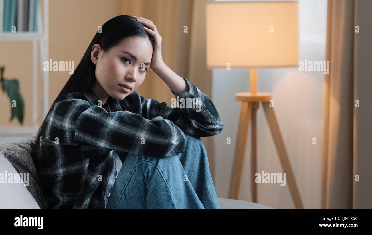 Alone tired boredom sad Asian woman exhausted girl sitting on couch at ...