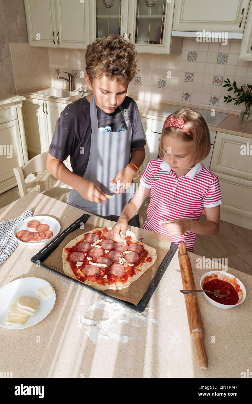 Children cook pizza together at home in the kitchen Stock Photo - Alamy