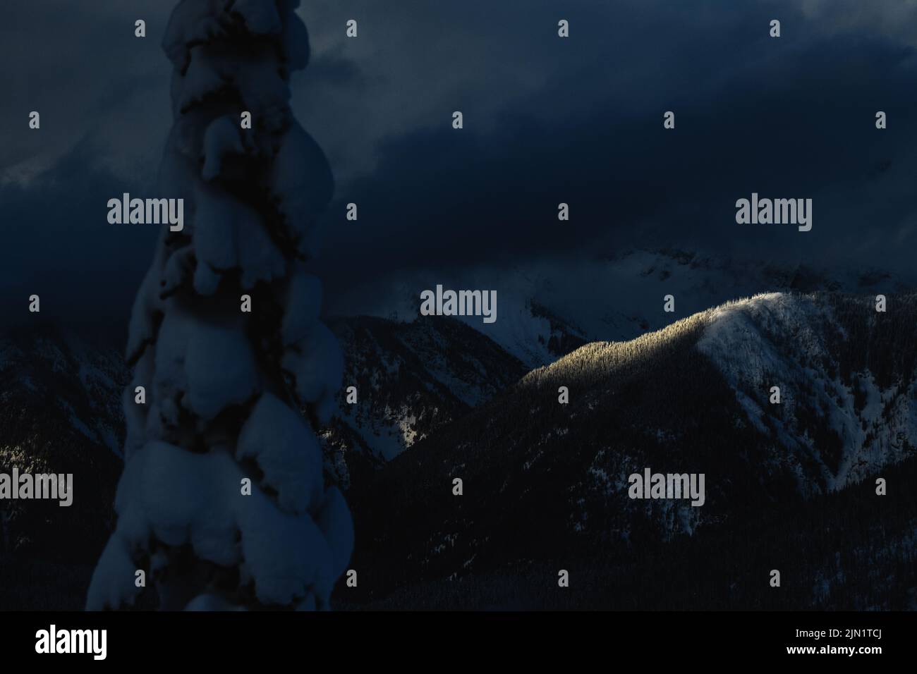 sliver of light on winter ridge line of selkirk mountains Stock Photo ...