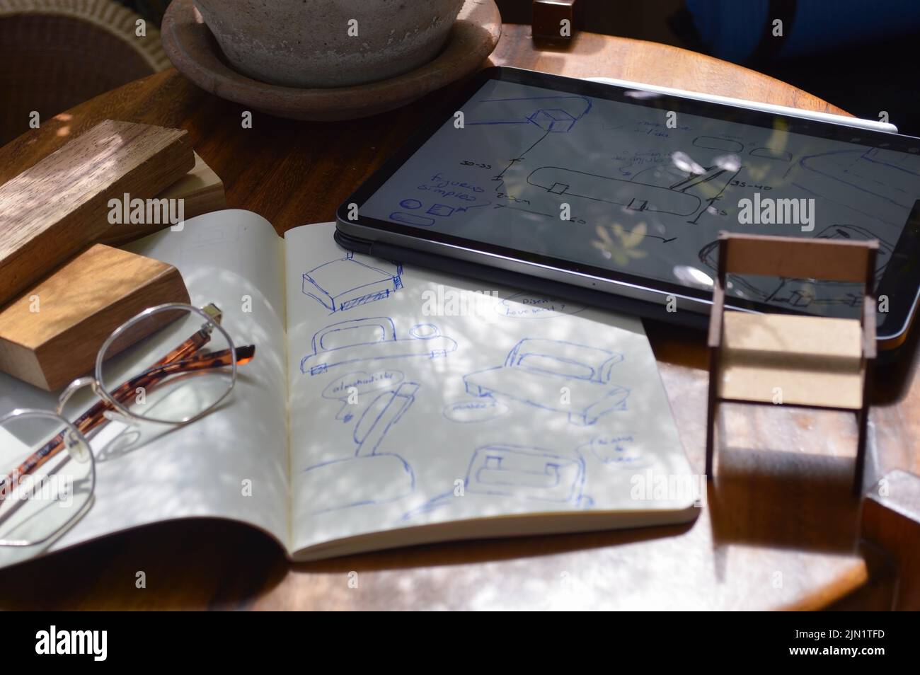 A closeup of a sketchbook and a tablet. Concept of furniture design ...