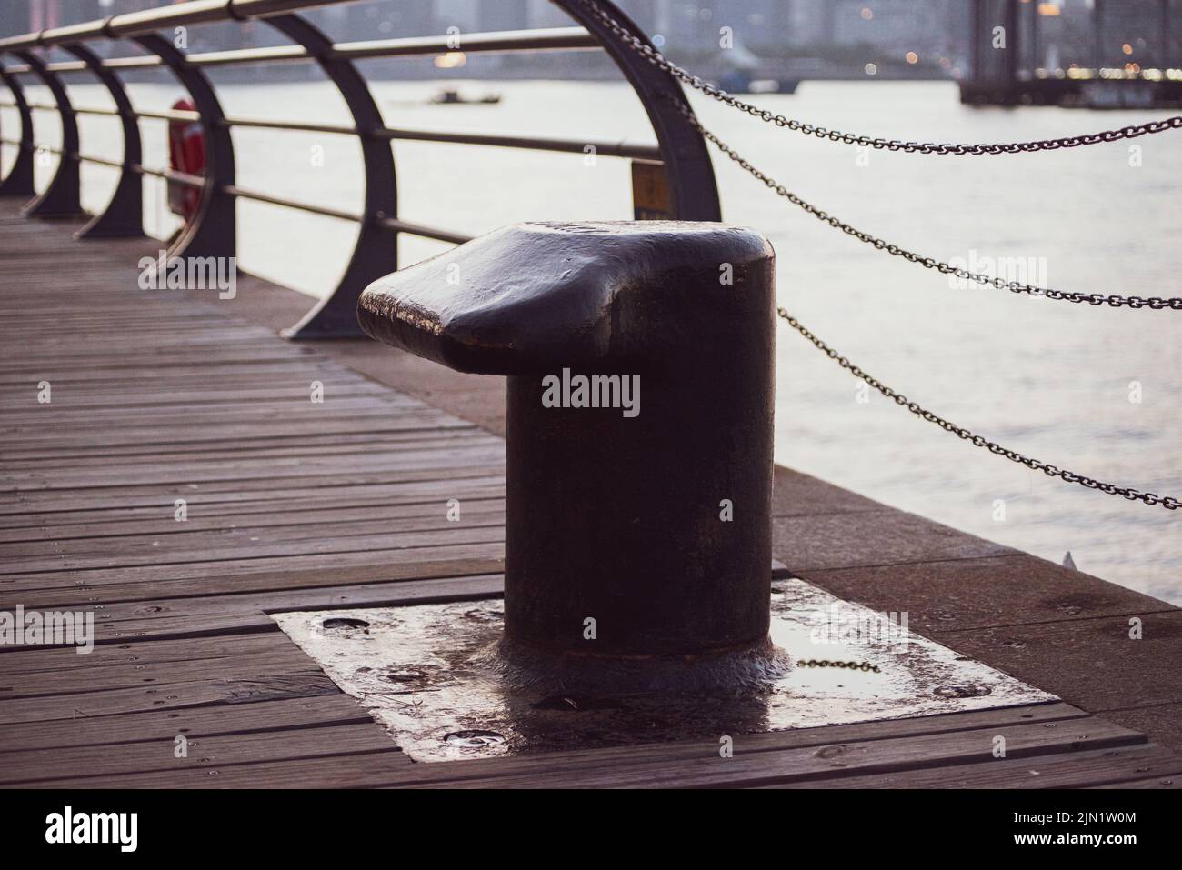 Black metal mooring bollard in marina and port terminal. Close up of ...