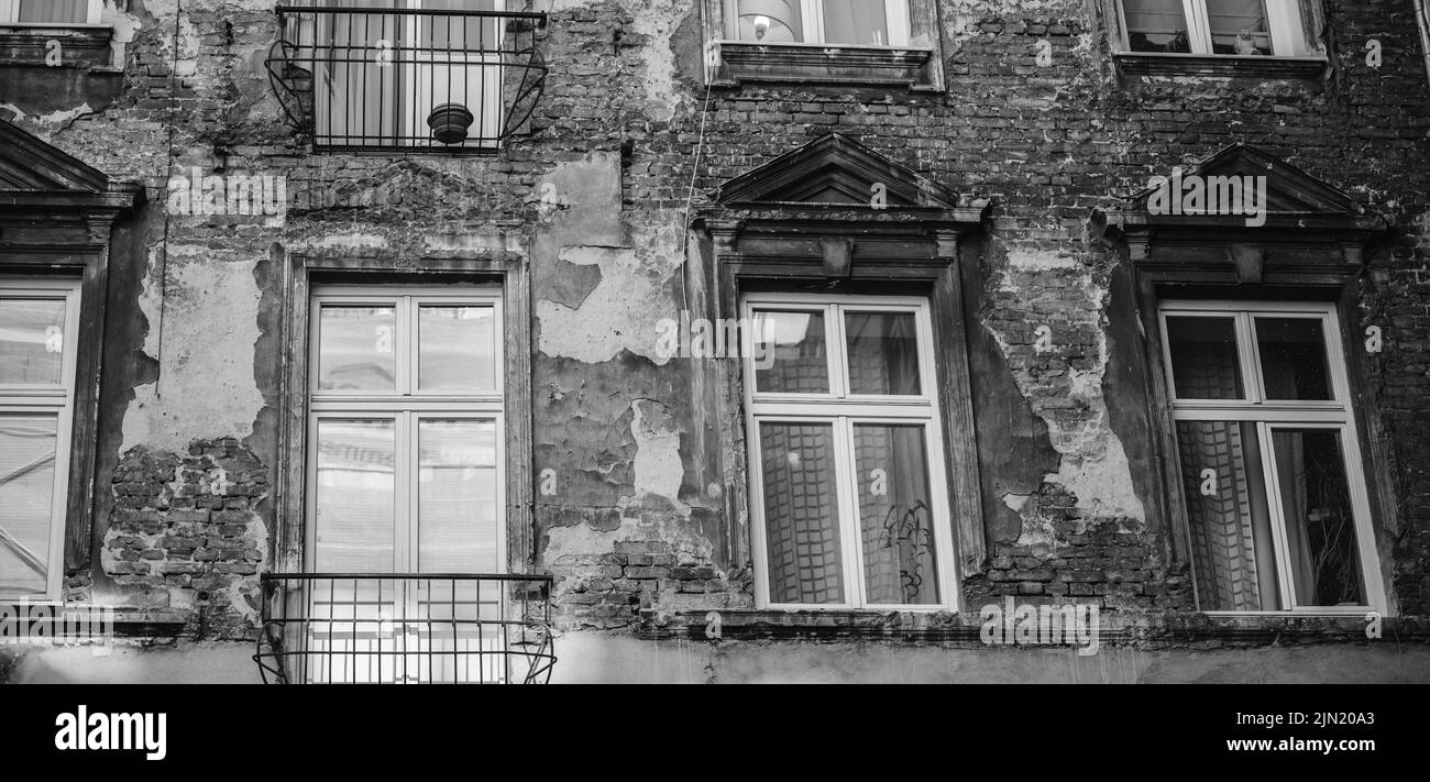 A grayscale of an ancient weathered building with old windows Stock ...
