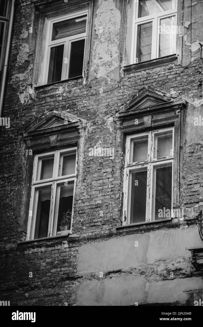 A grayscale of an ancient weathered building with old windows Stock ...