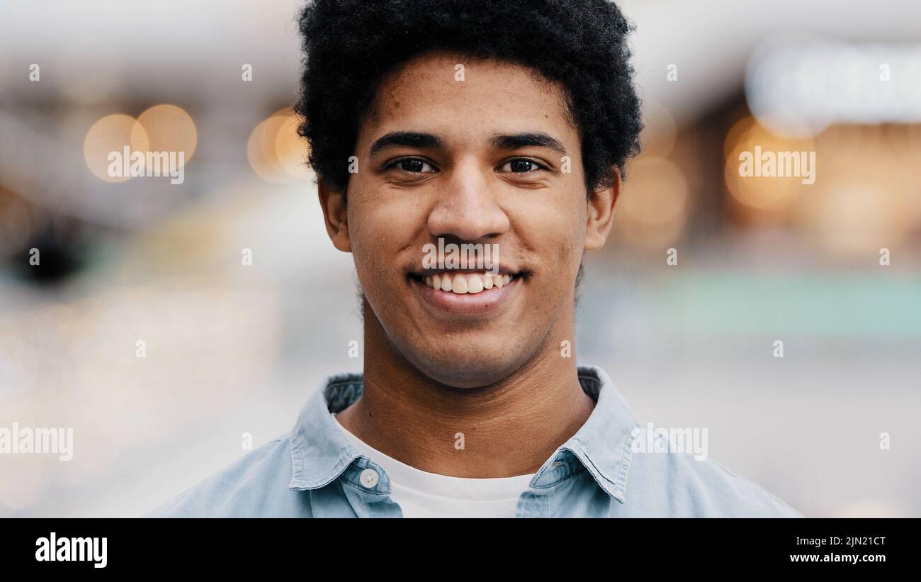 Front view portrait male face close-up african millennial man guy looking at camera smiling ...