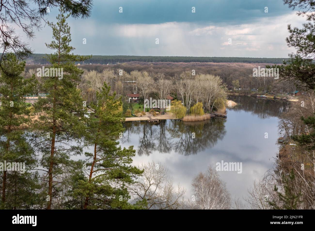 Spring rainy clouds on river bank recreation area in pine forest ...