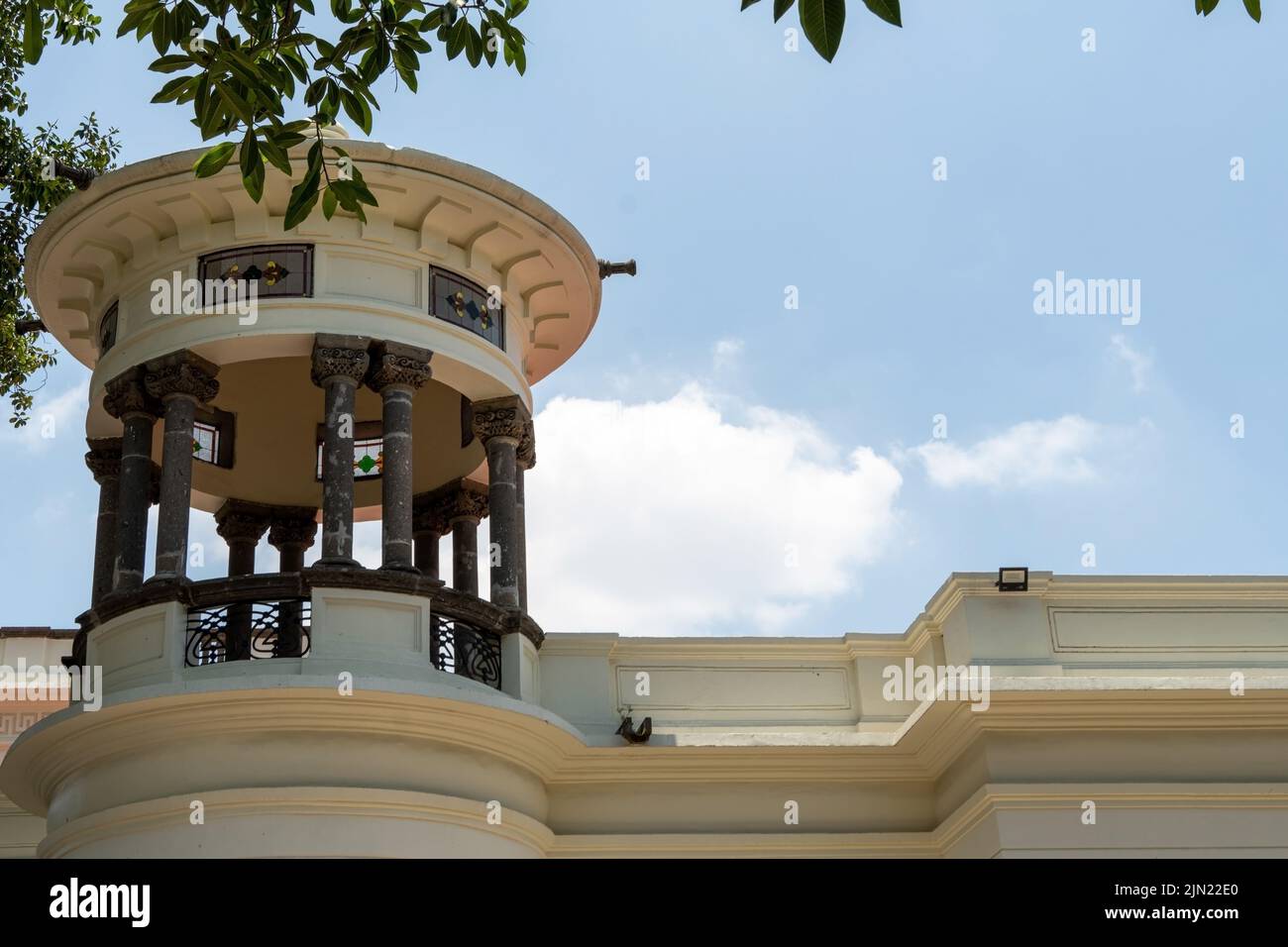 An elegant white building with patterned black columns supporting a ...