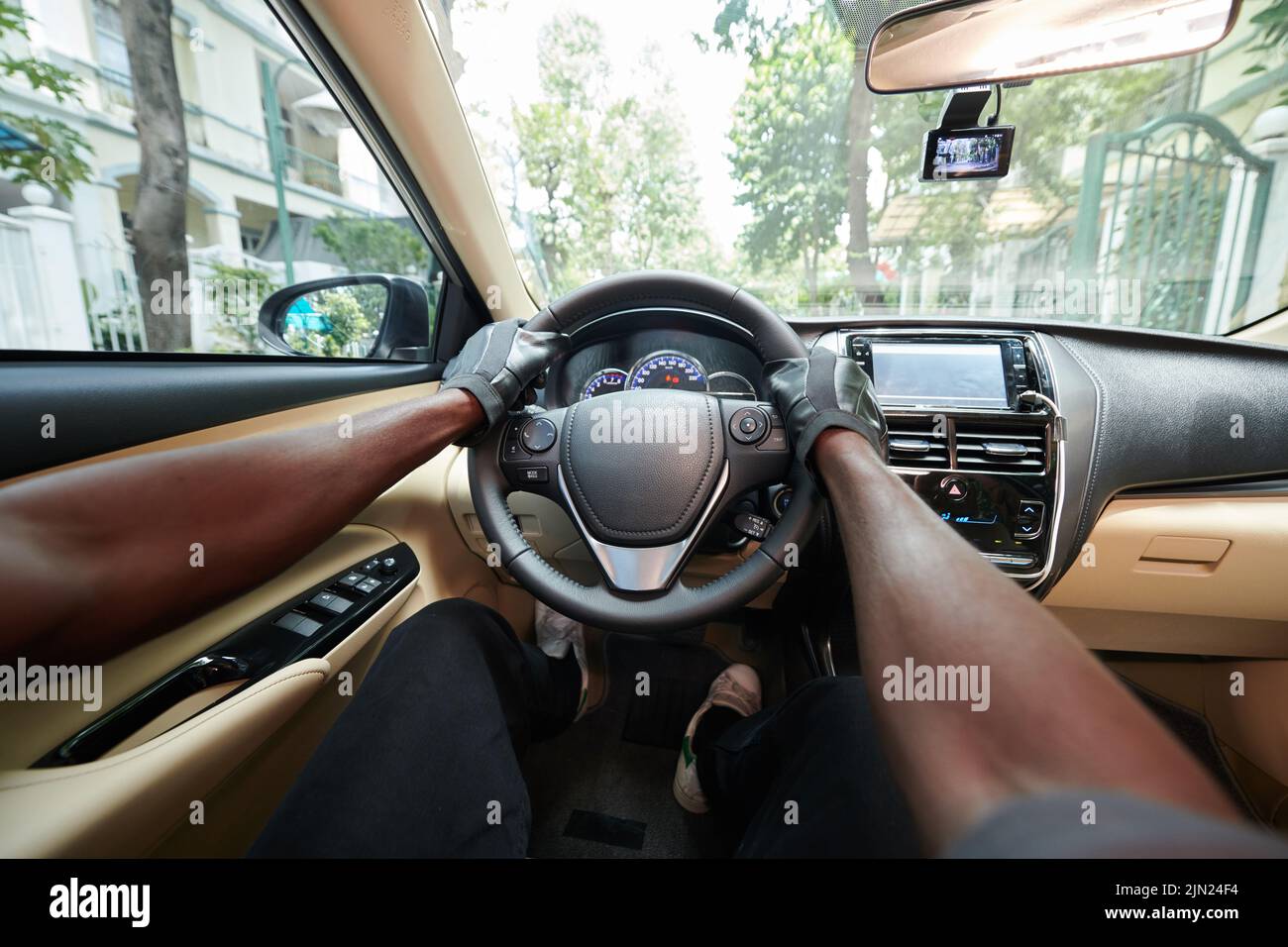 First person view of Black man in leather gloves driving car in city ...