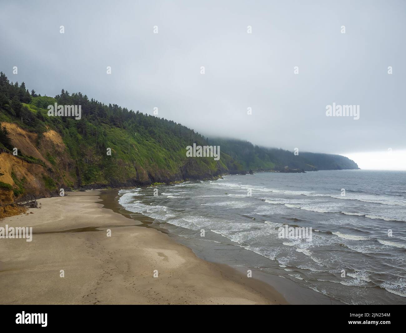 Calm seascape. The white waves of the ocean float on the sandy shore ...