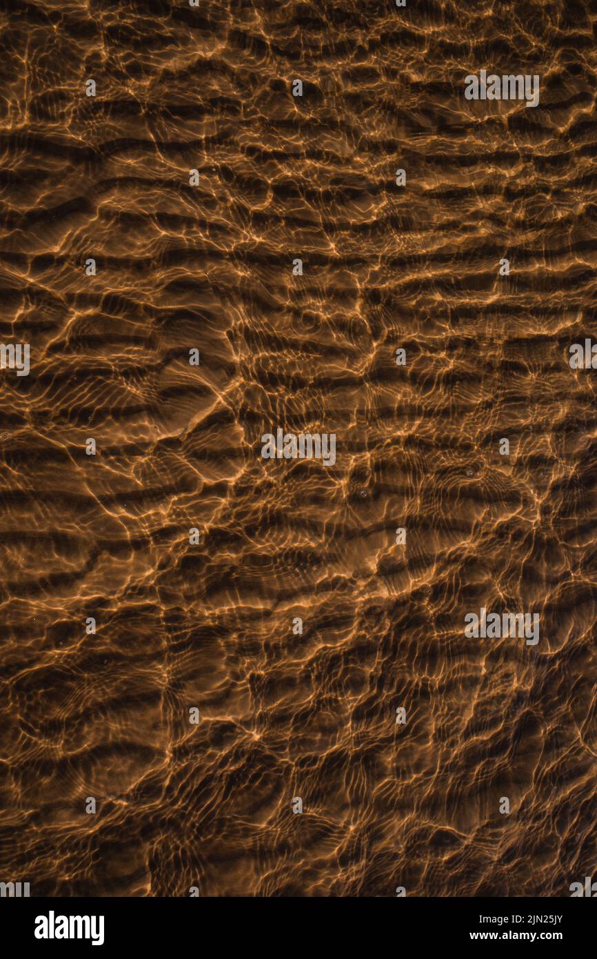 Clear sea water with golden brown sand beach and sundown sunlight that ...