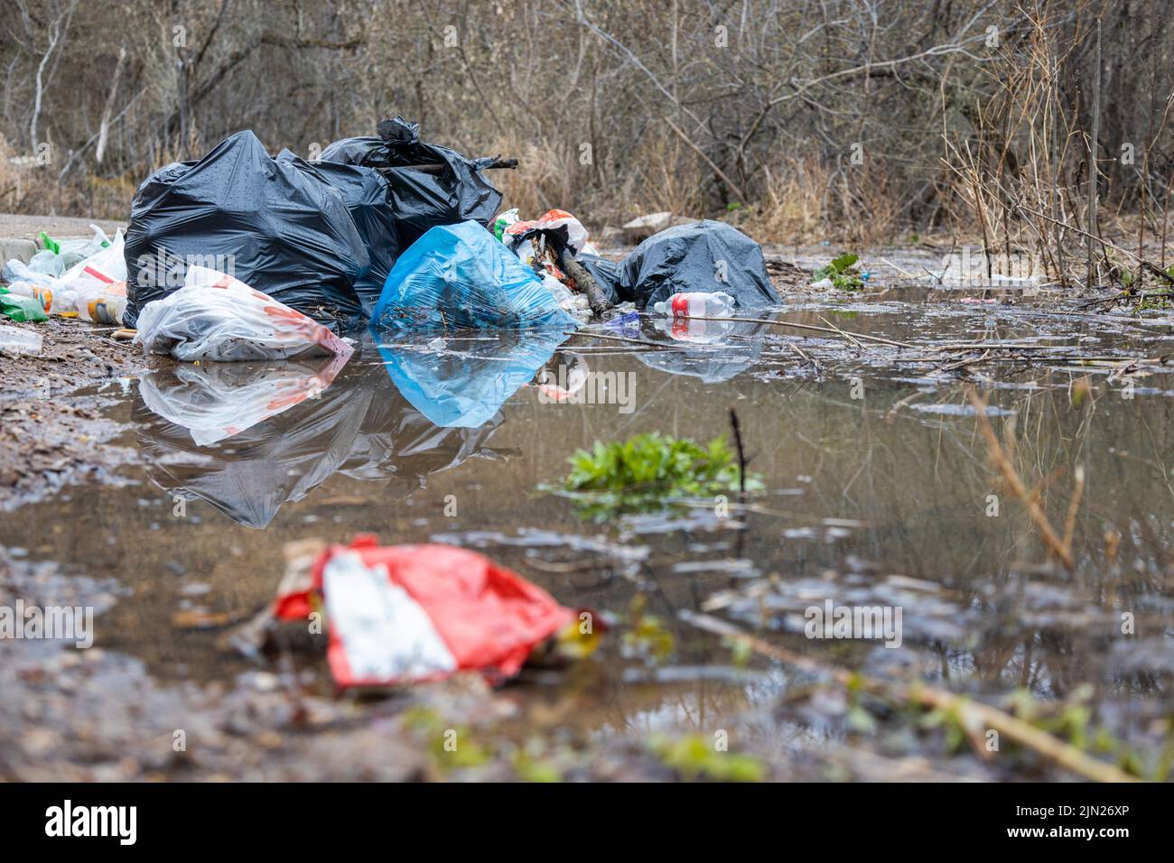 Abandoned garbage plastic and glass waste in nature among the grass ...