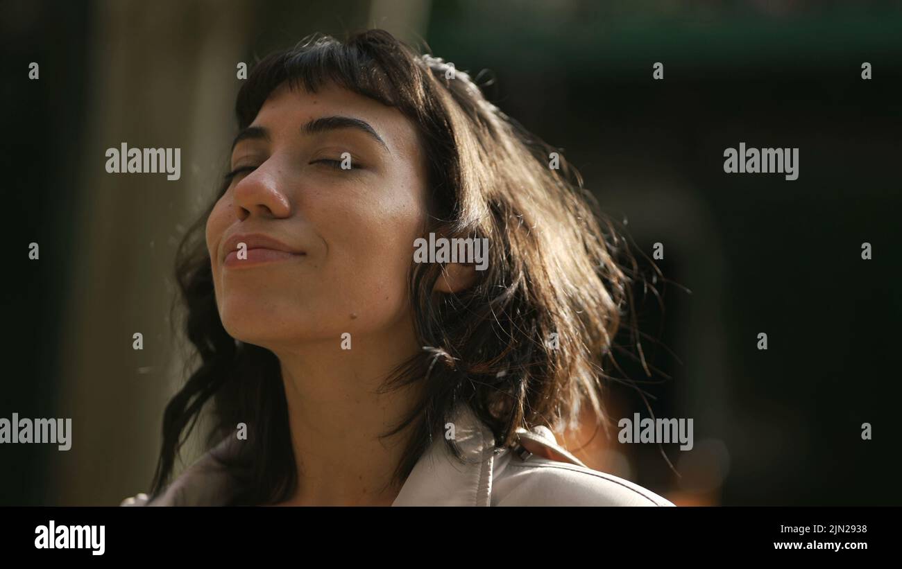 Relaxed young woman with eyes closed standing outside in nature in ...