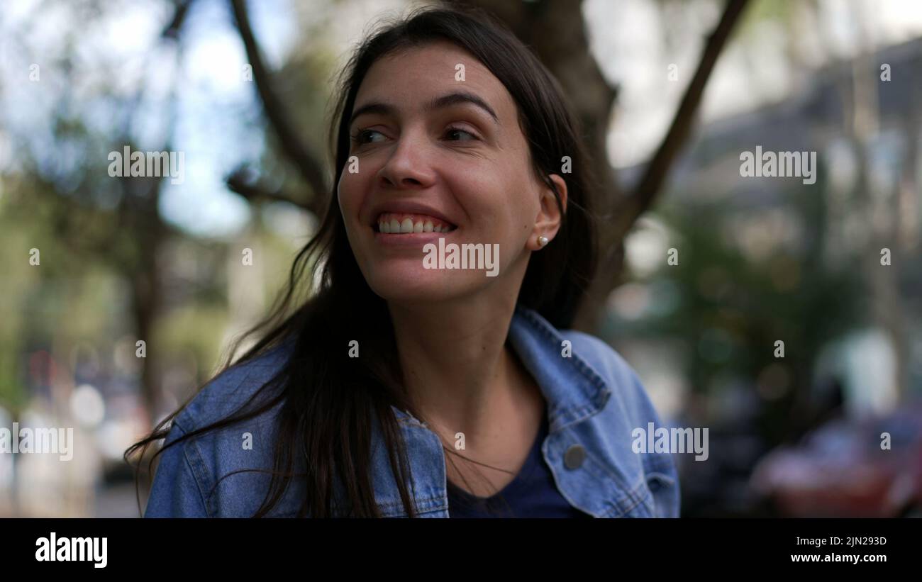 Portrait of a happy young woman walking forward in city. Smiling person ...