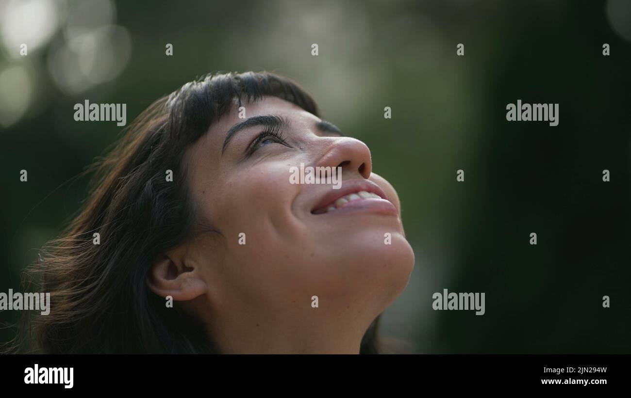 Faithful South American woman closing eyes in meditation looking at sky ...