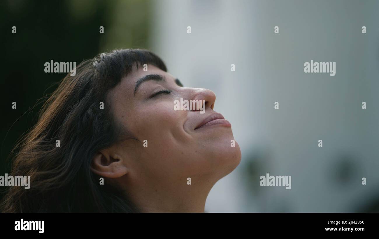 Faithful South American woman closing eyes in meditation looking at sky ...