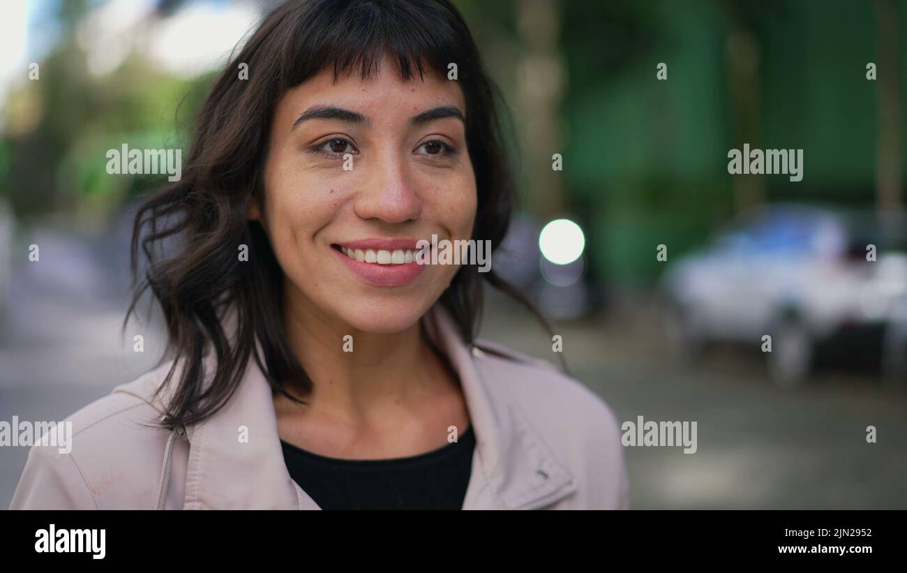 A happy Brazilian young woman walking forward smiling face closeup ...