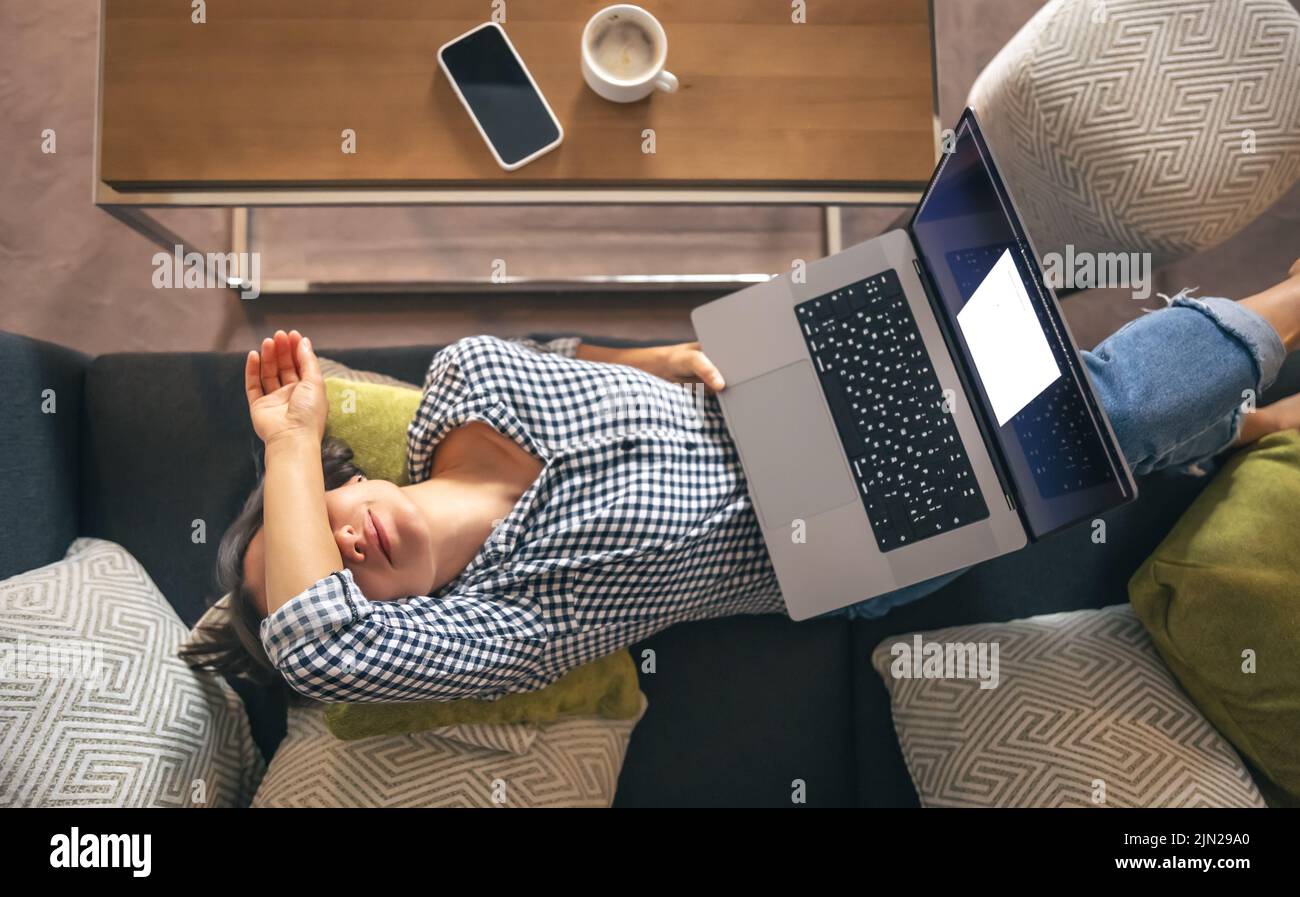 Tired from work young woman in front of a laptop Stock Photo - Alamy