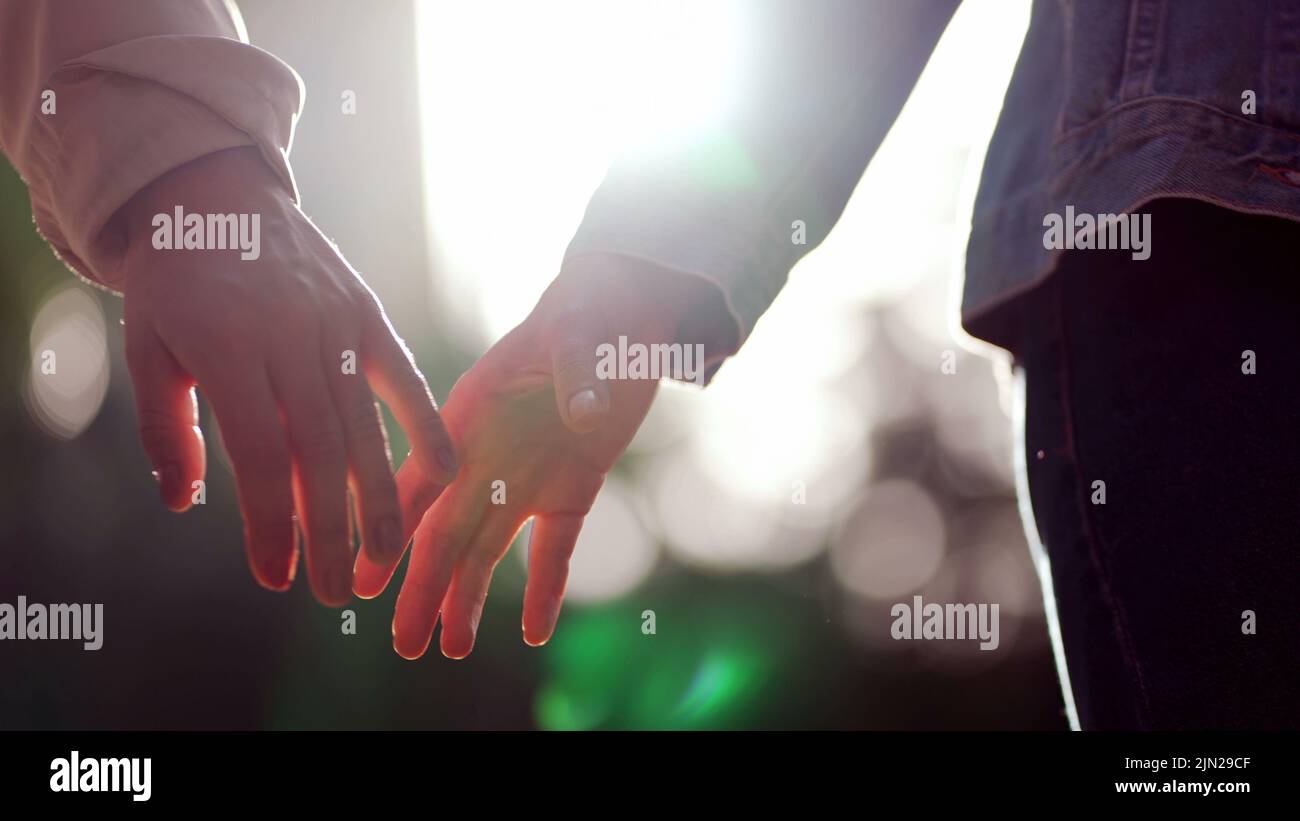 Hands joining together with sunlight flare in the background. Beautiful ...