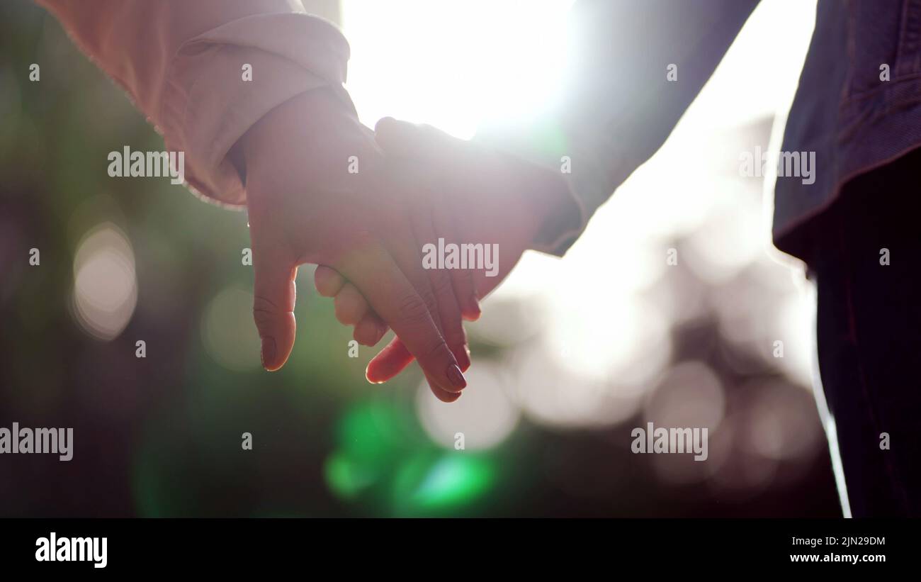 Hands joining together with sunlight flare in the background. Beautiful ...