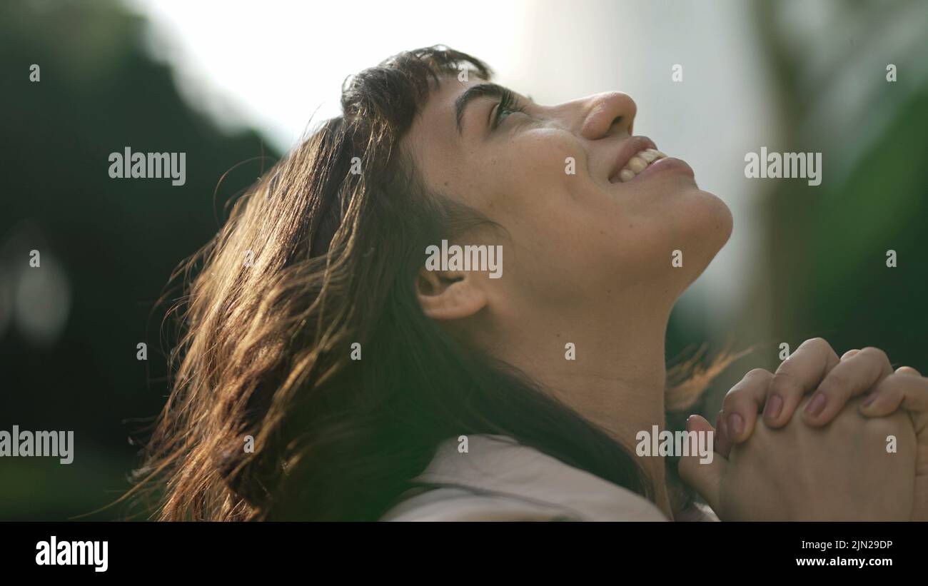 Grateful woman having HOPE praying to God. Spiritual girl smiling to ...