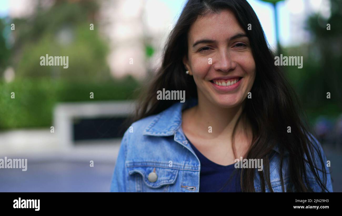 Confident happy woman walking forward in street looking at camera ...