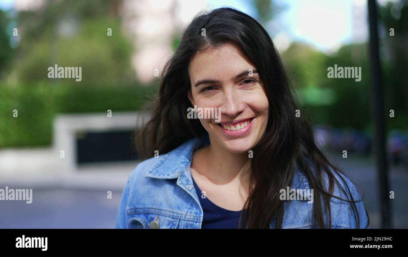 Confident happy woman walking forward in street looking at camera ...