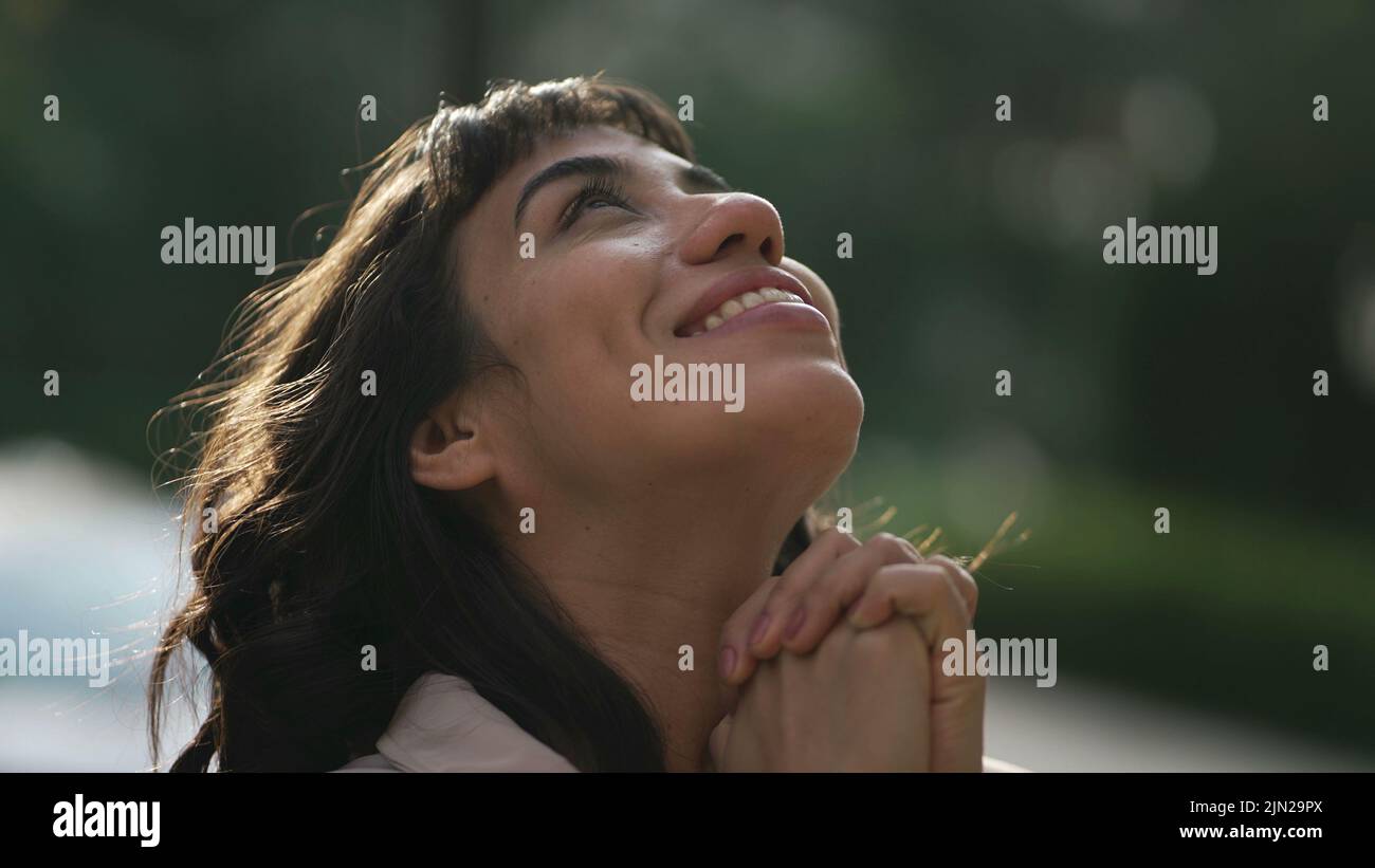 Hopeful woman praying to God standing outside looking at sky. Girl ...