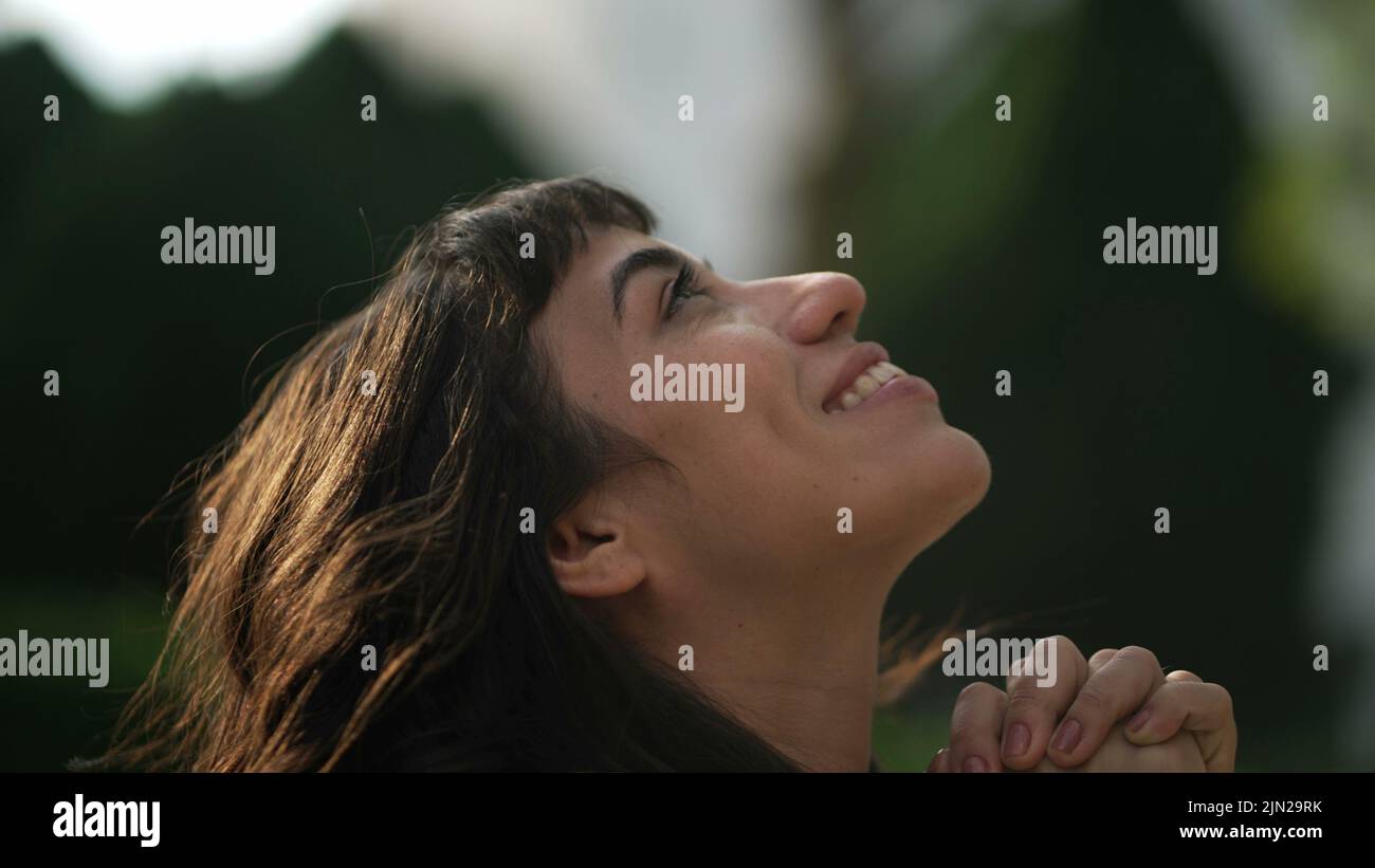Hopeful woman praying to God standing outside looking at sky. Girl ...