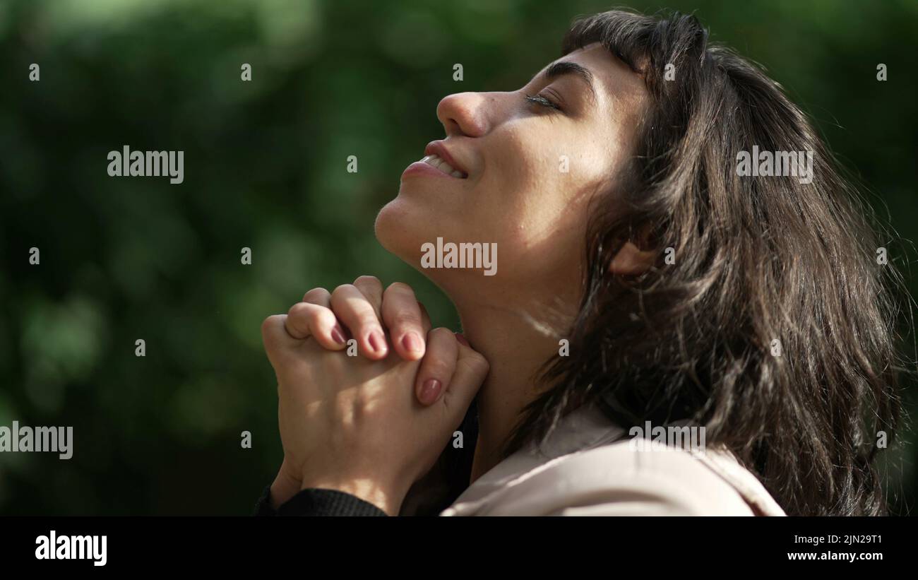 Hopeful woman praying to God standing outside looking at sky. Girl ...